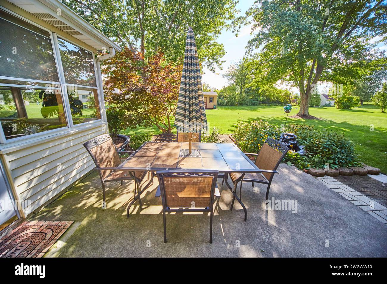 Suburban Backyard Oasis with Patio Dining Set and Garden Decor Stock ...