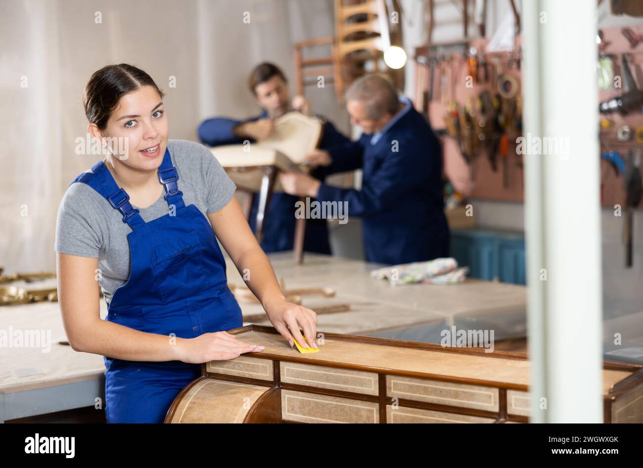 Portrait of skillful repair woman carpenter renovating dresser ...