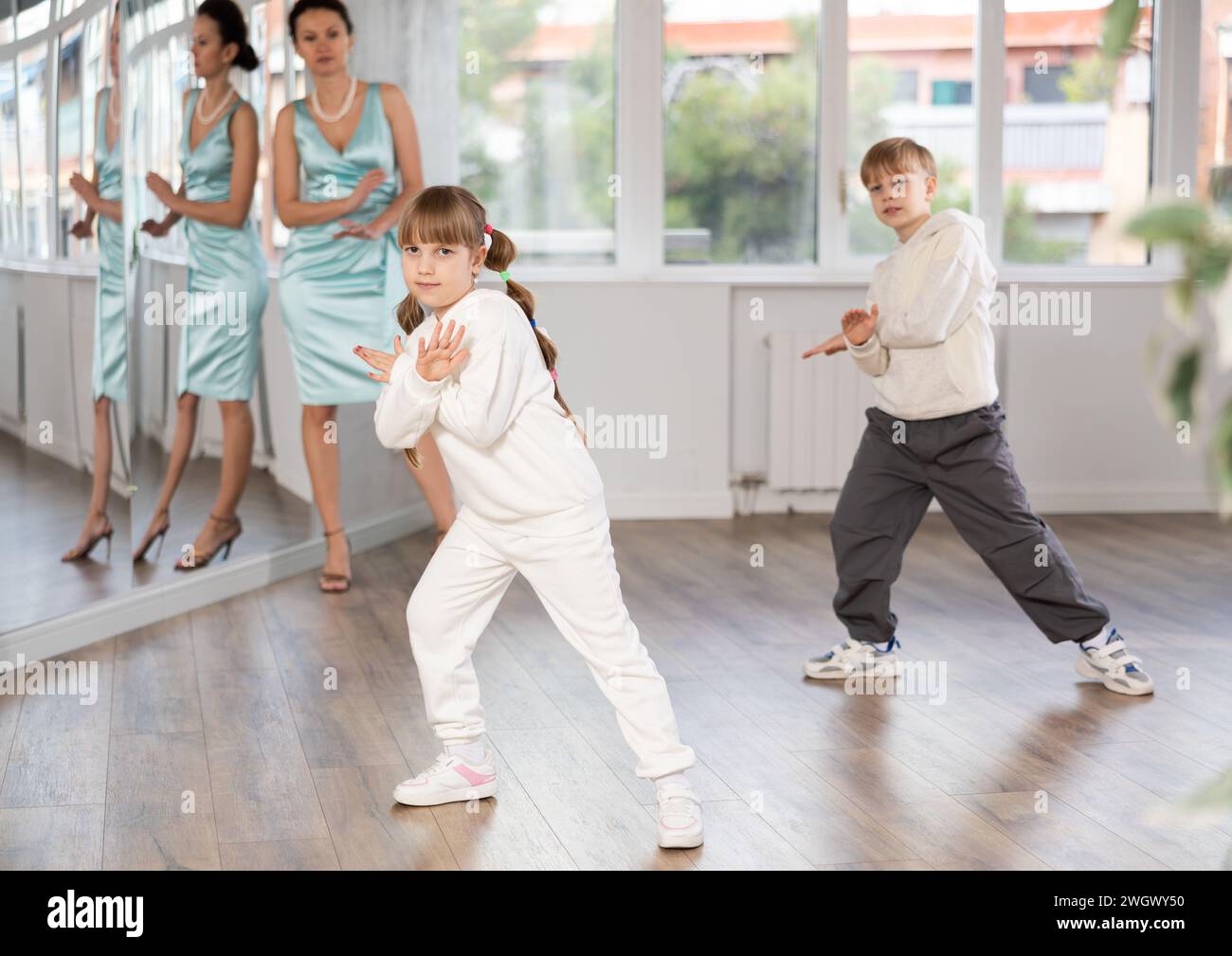 Tween girl and boy rehearsing popping techniques in street dance studio ...