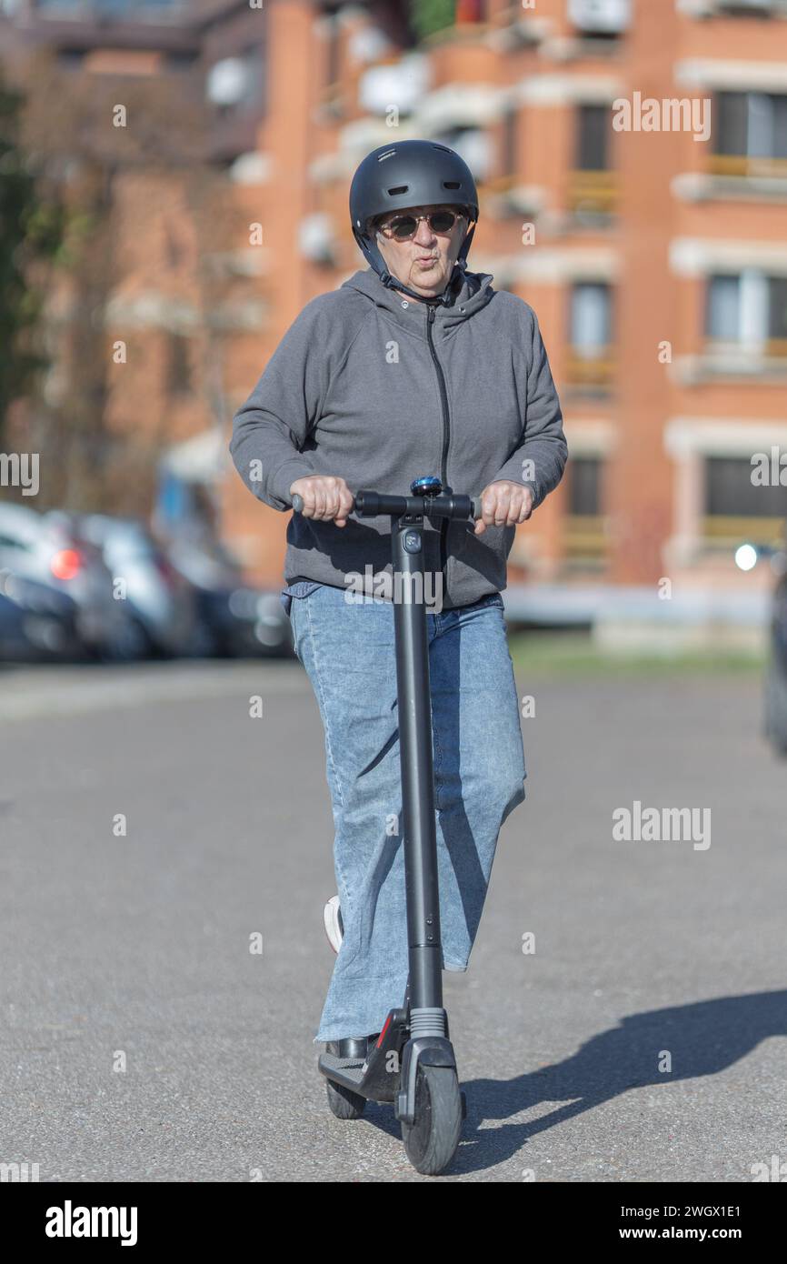 elderly woman riding an electric scooter Stock Photo - Alamy