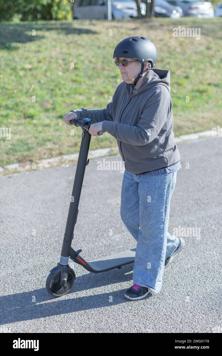 elderly woman riding an electric scooter Stock Photo - Alamy