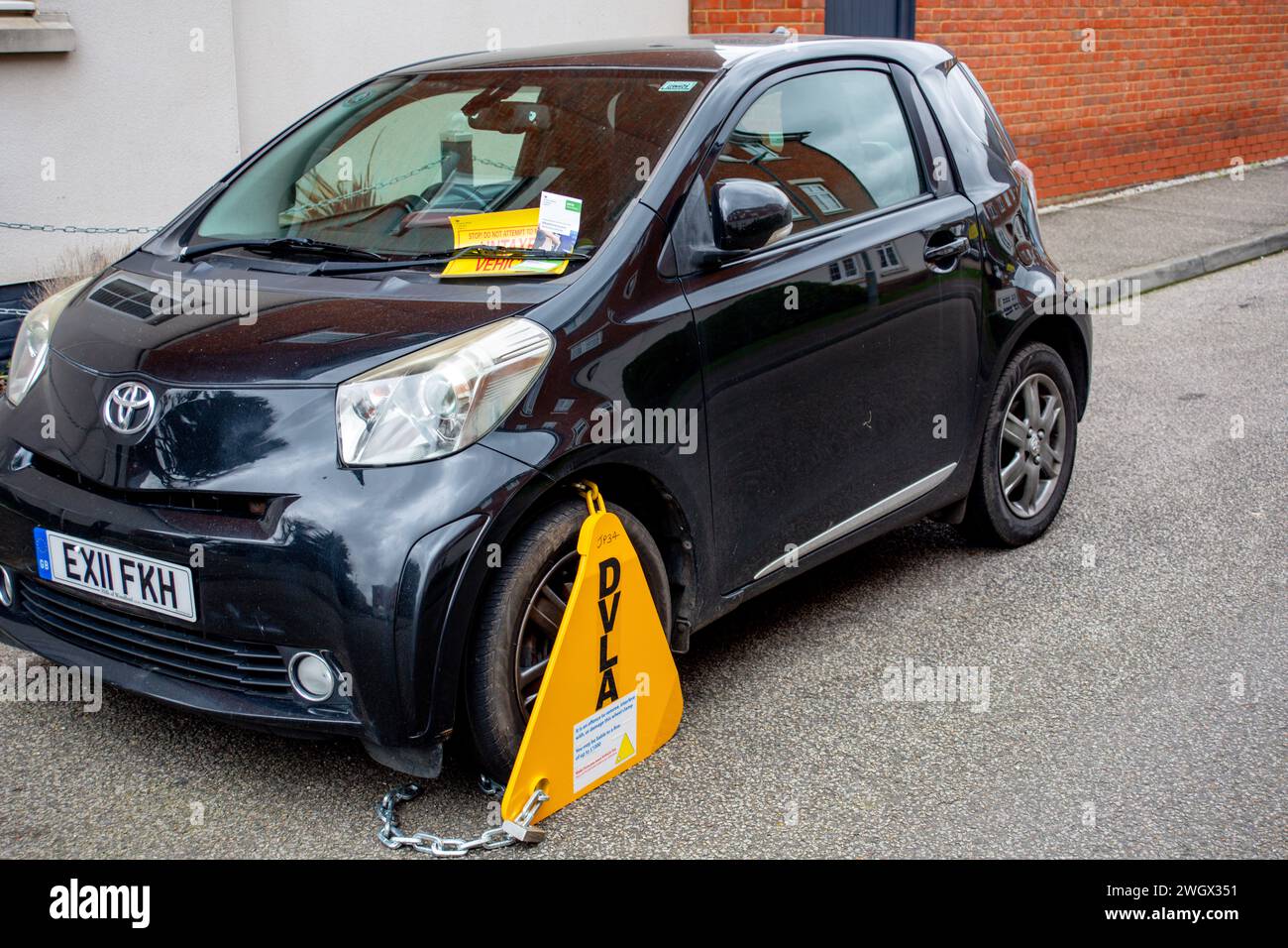 Clamped, untaxed car with notice for driving offence Stock Photo - Alamy