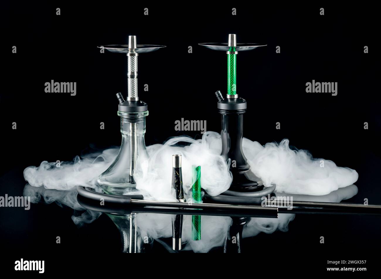 Two hookahs with white puffs of smoke on a black mirror background ...