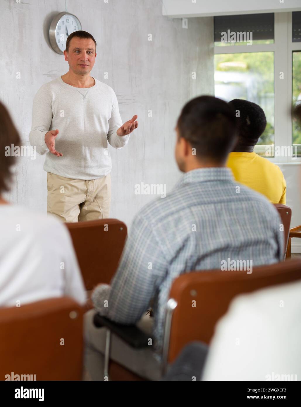 Man conducting educational class for male group in auditorium Stock ...