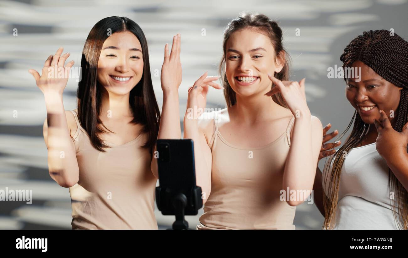 Silly beauty models dancing and having fun on camera, recording video with dance moves on ...