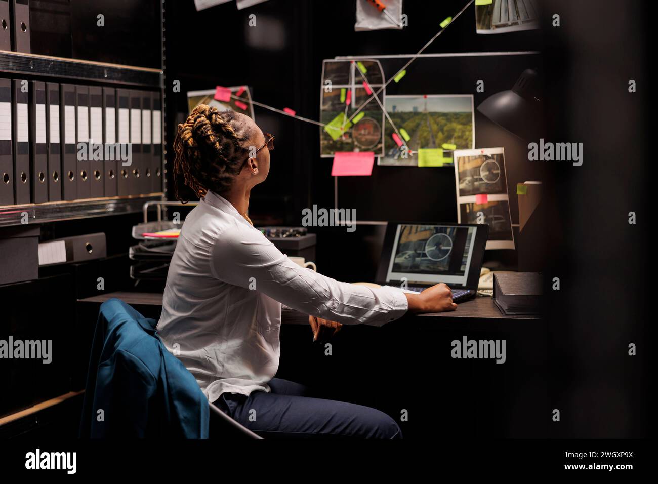 African american policewoman analyzing evidence board while solving ...