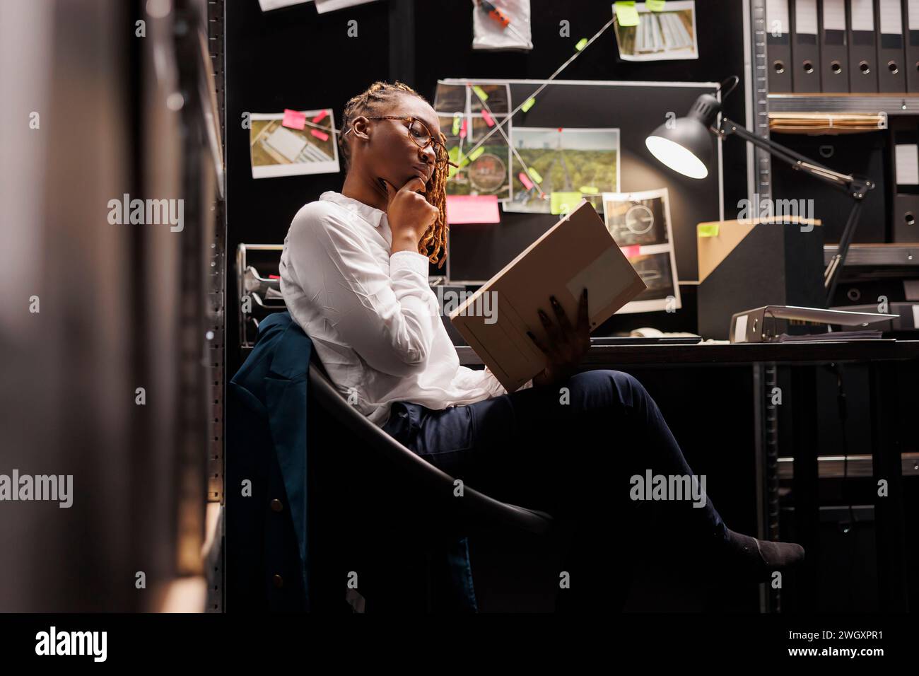 Thoughtful woman investigator reviewing forensic expertise report and ...