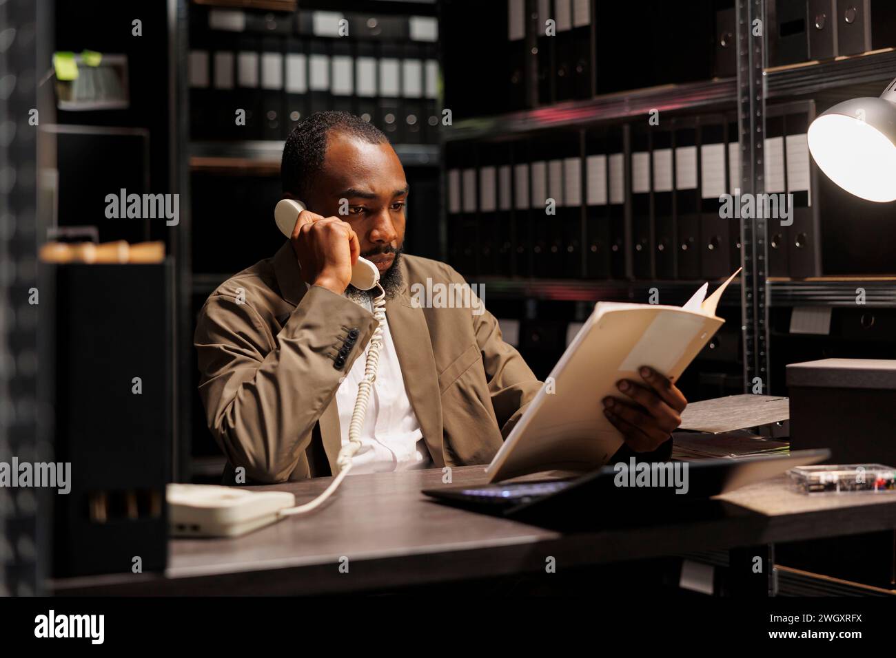 Private detective discussing investigation with client on landline ...