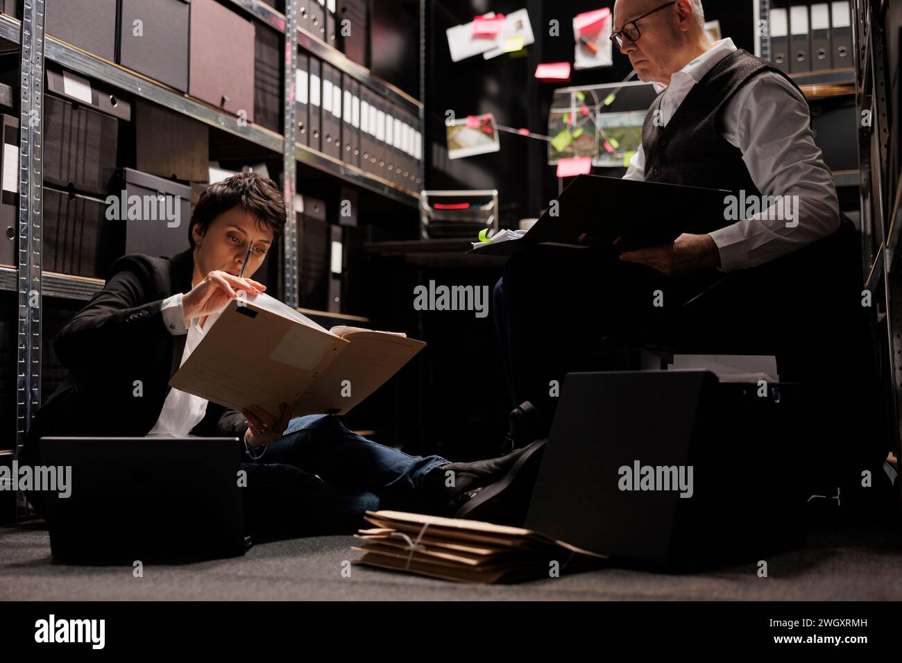 Tired police officers holding files with crime scene evidence ...