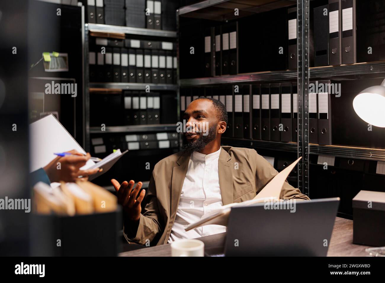 Detective discussing crime solving ideas with assistant in office at ...