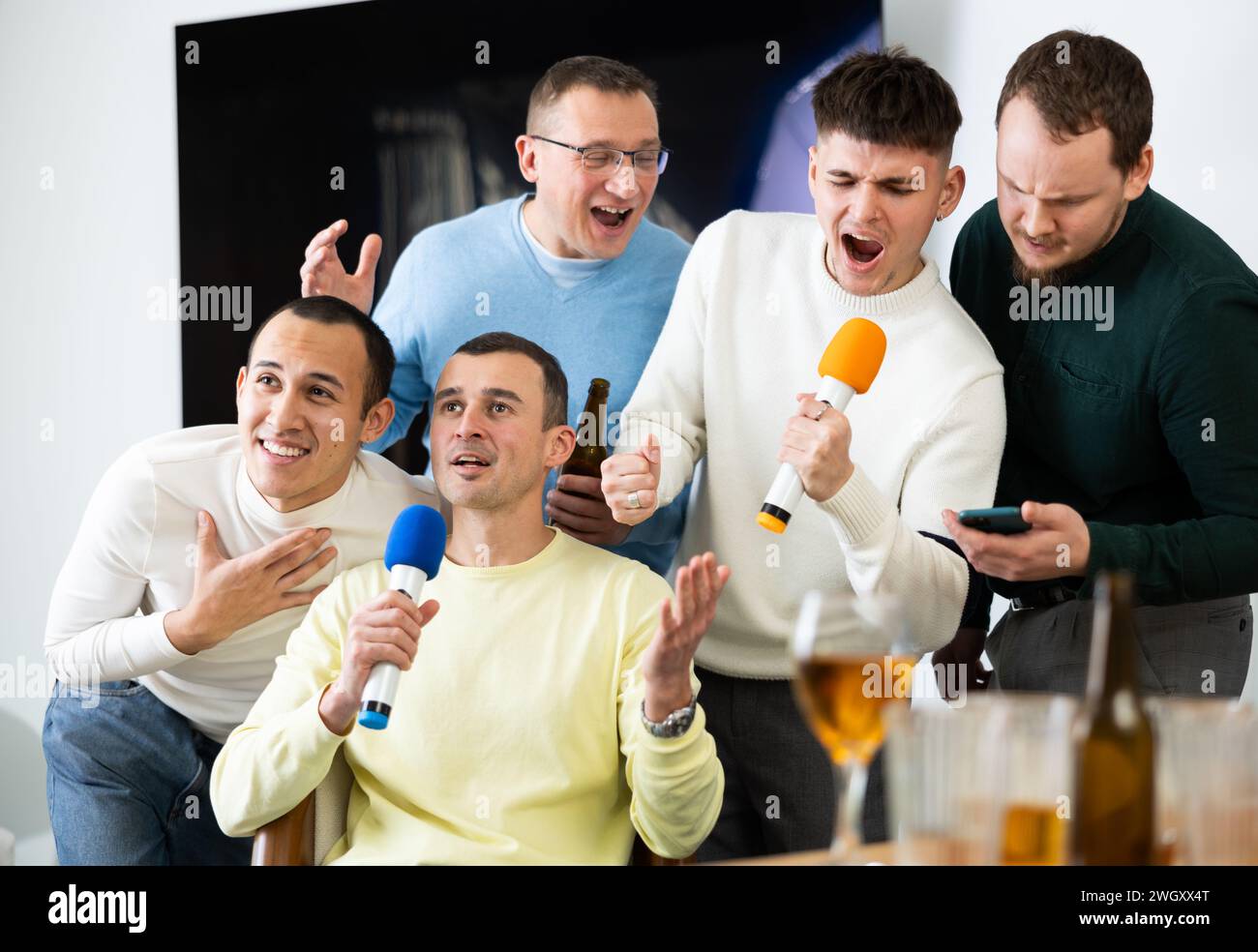 Cheerful young adults singing karaoke hi-res stock photography and ...