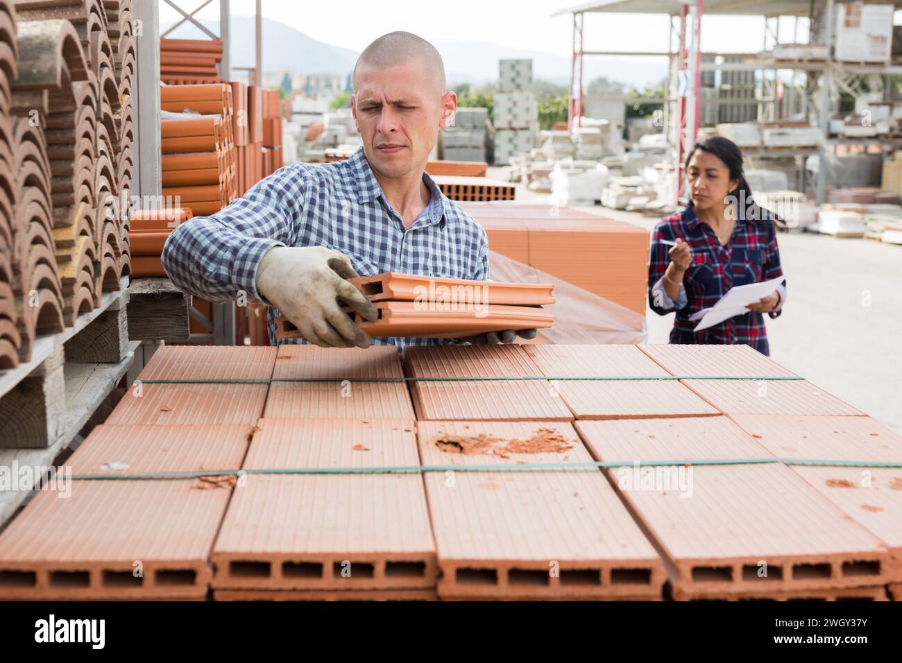 Worker stacking bricks in warehouse of materials Stock Photo - Alamy