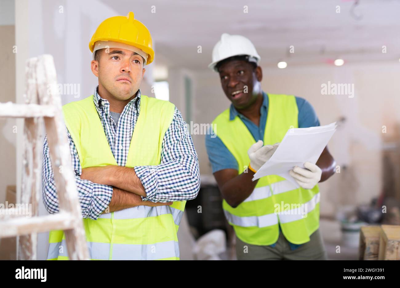 Portrait of confused man builder and angry foreman in construction site ...