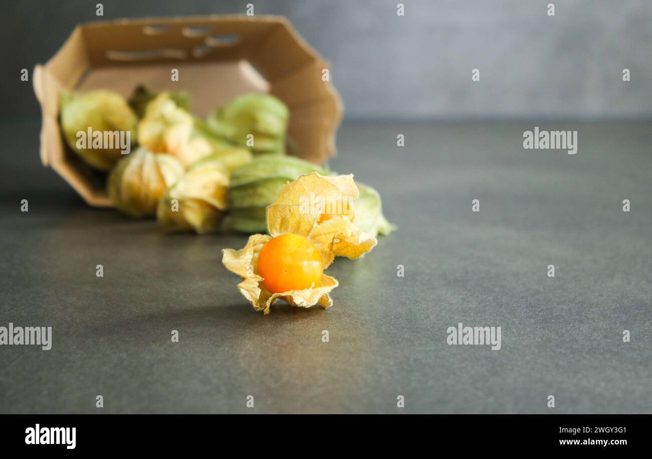 Ripe delicious physalis fruit in a paper box on grey table Stock Photo ...
