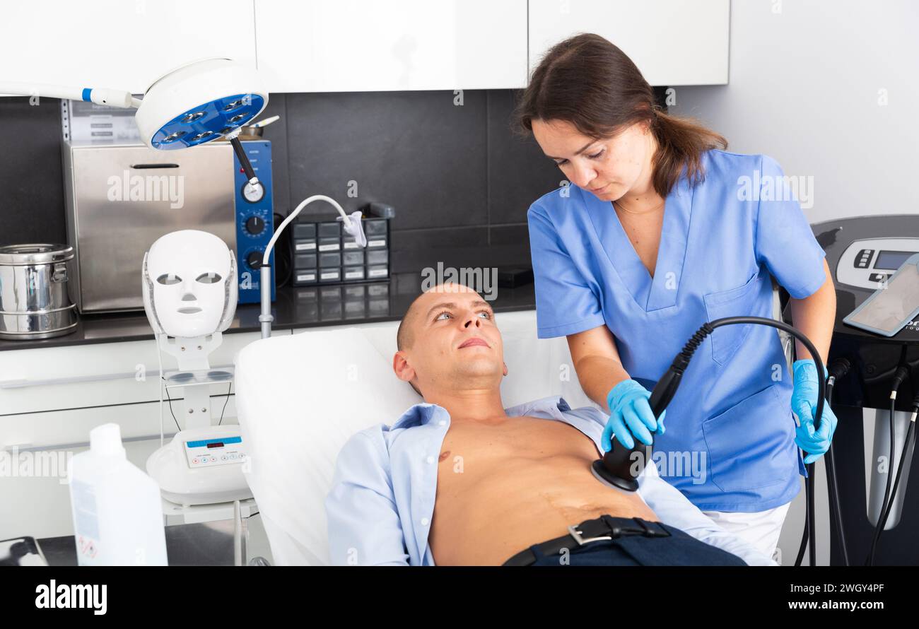 Man getting ultrasound procedure for body contouring Stock Photo - Alamy