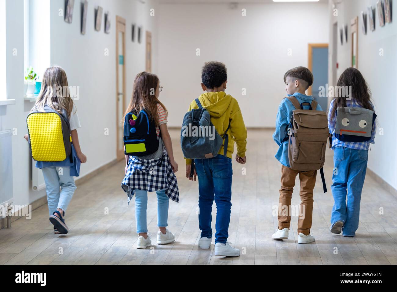 Back view of group of elementary school kids standing in school ...