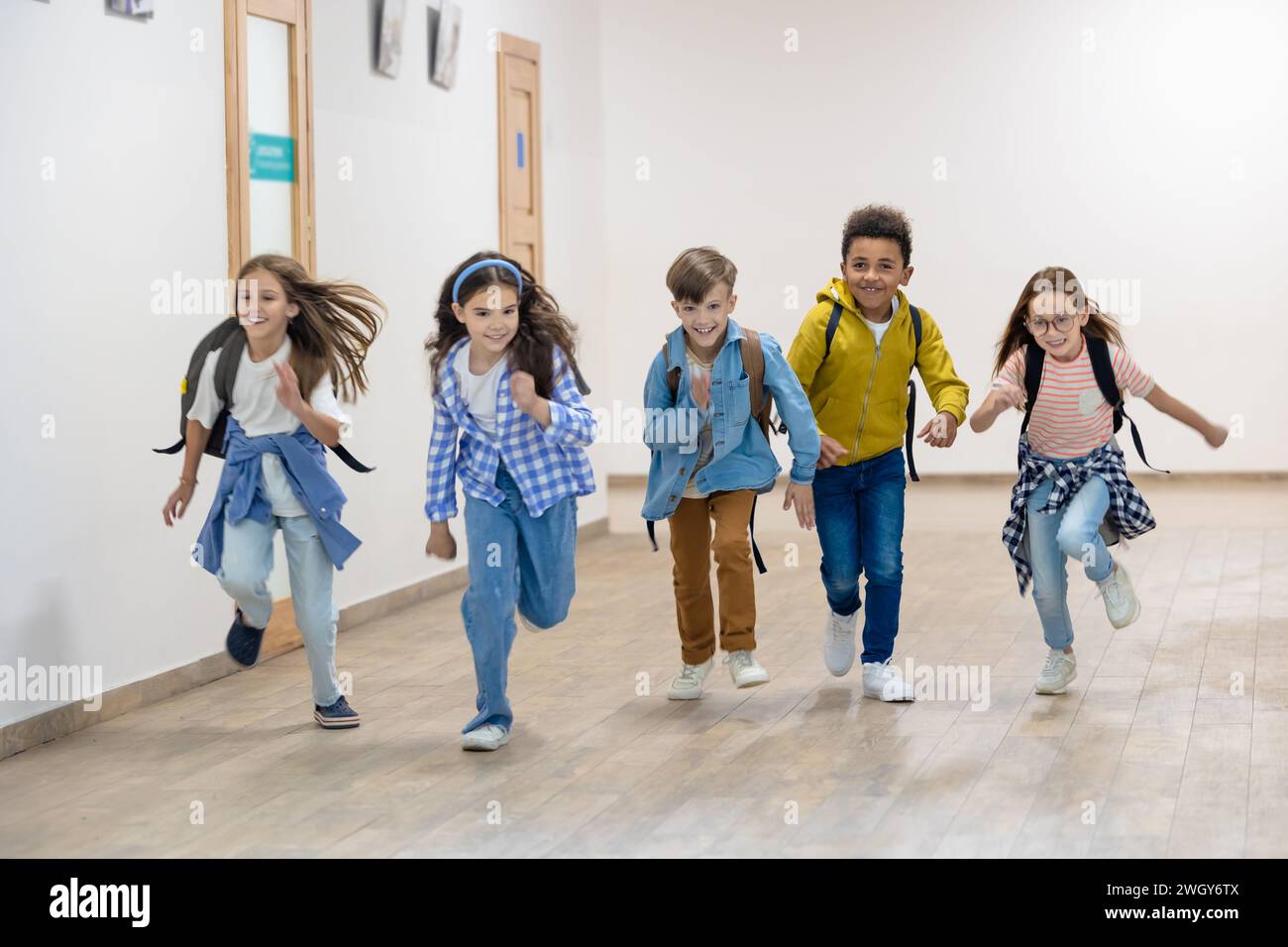 Group of elementary school kids running in school corridor Stock Photo ...