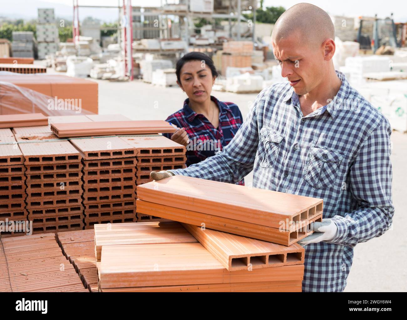 Worker stacking bricks in warehouse of materials Stock Photo - Alamy