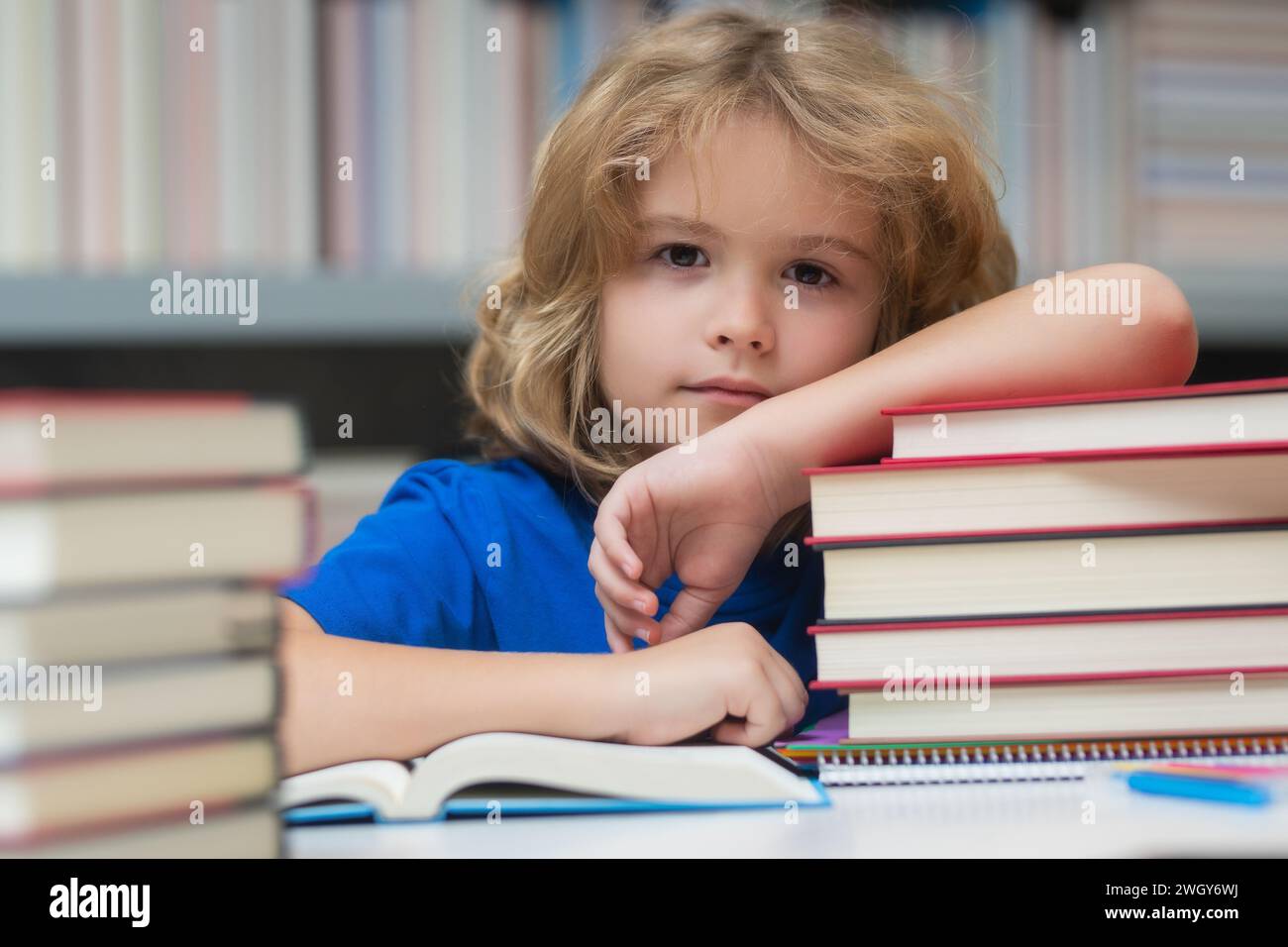 Child reading book in library on bookshelf background Stock Photo - Alamy