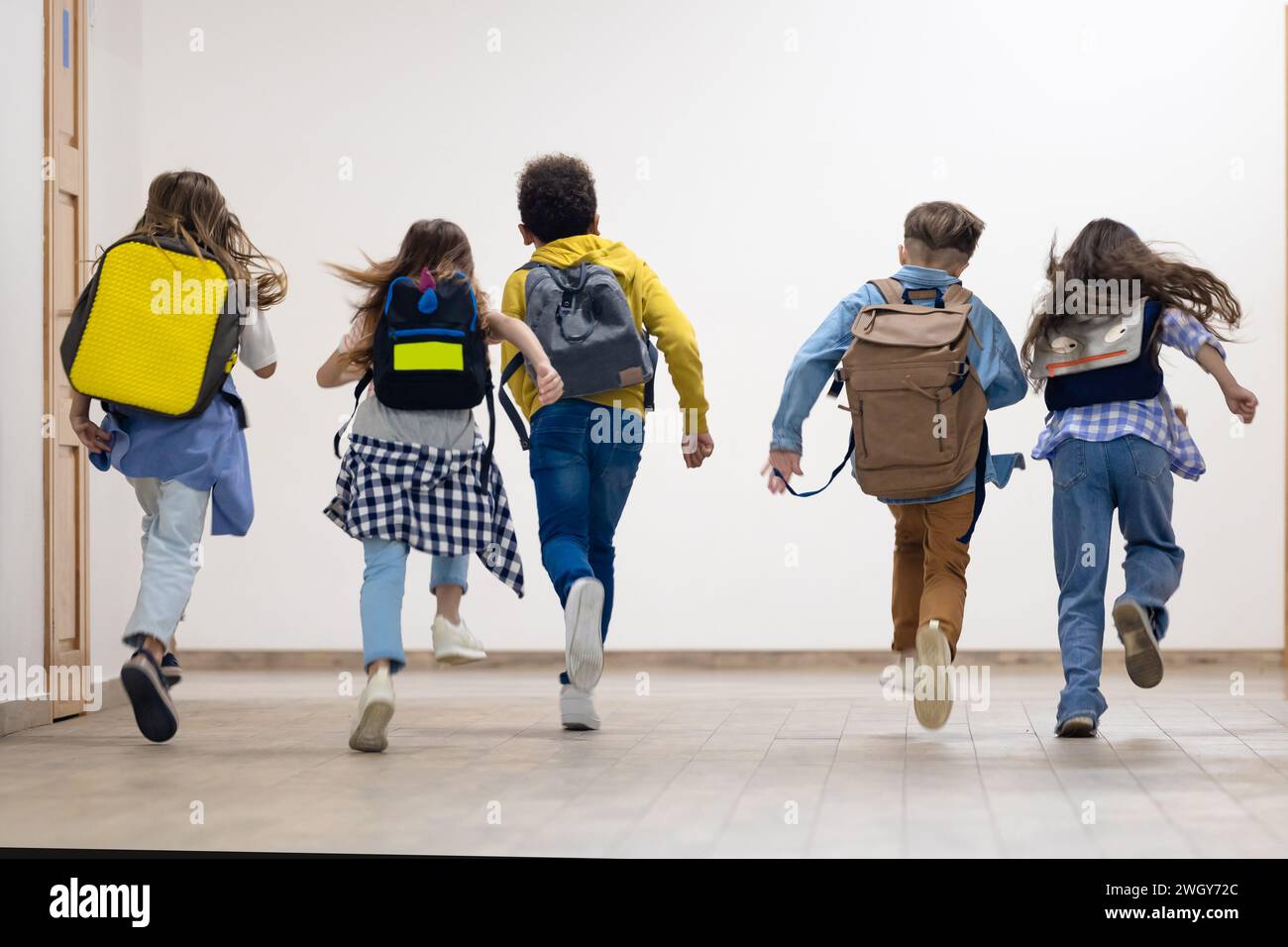 Group of elementary school kids running in school corridor Stock Photo ...