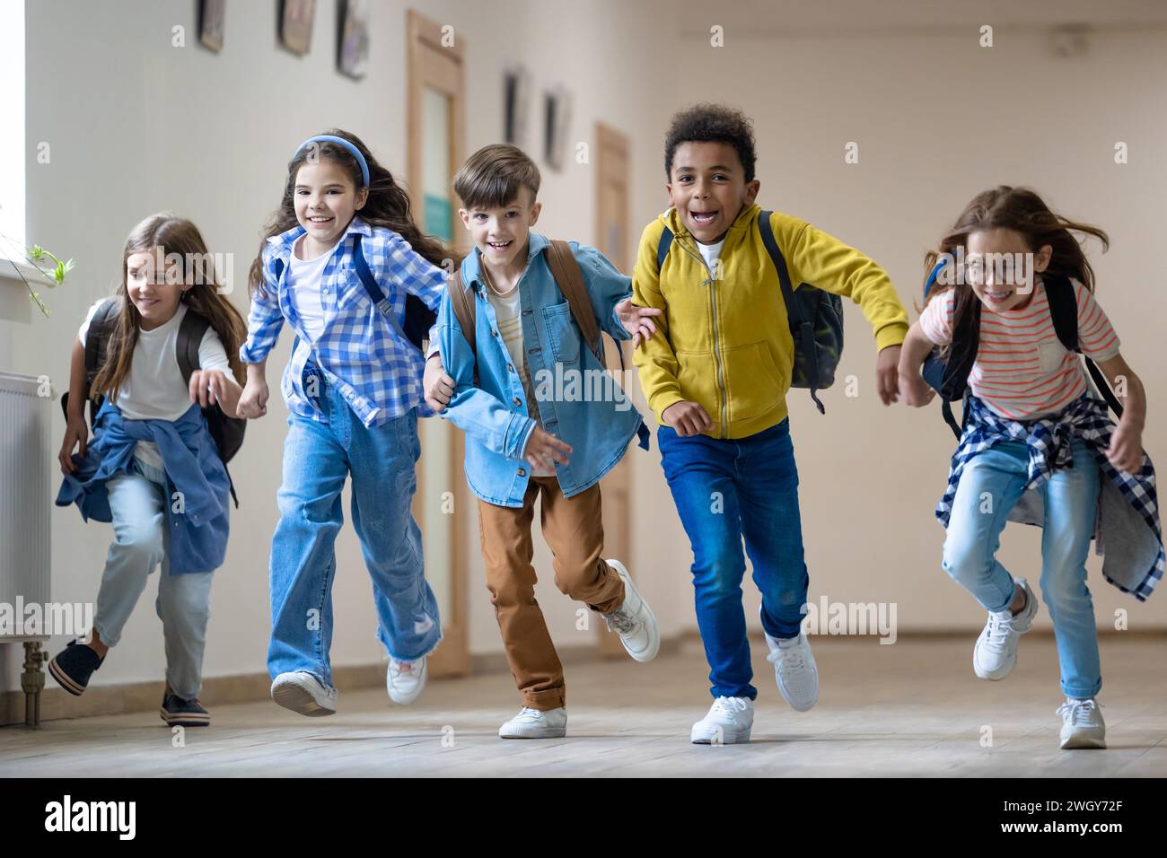 Group of elementary school kids running in school corridor Stock Photo ...