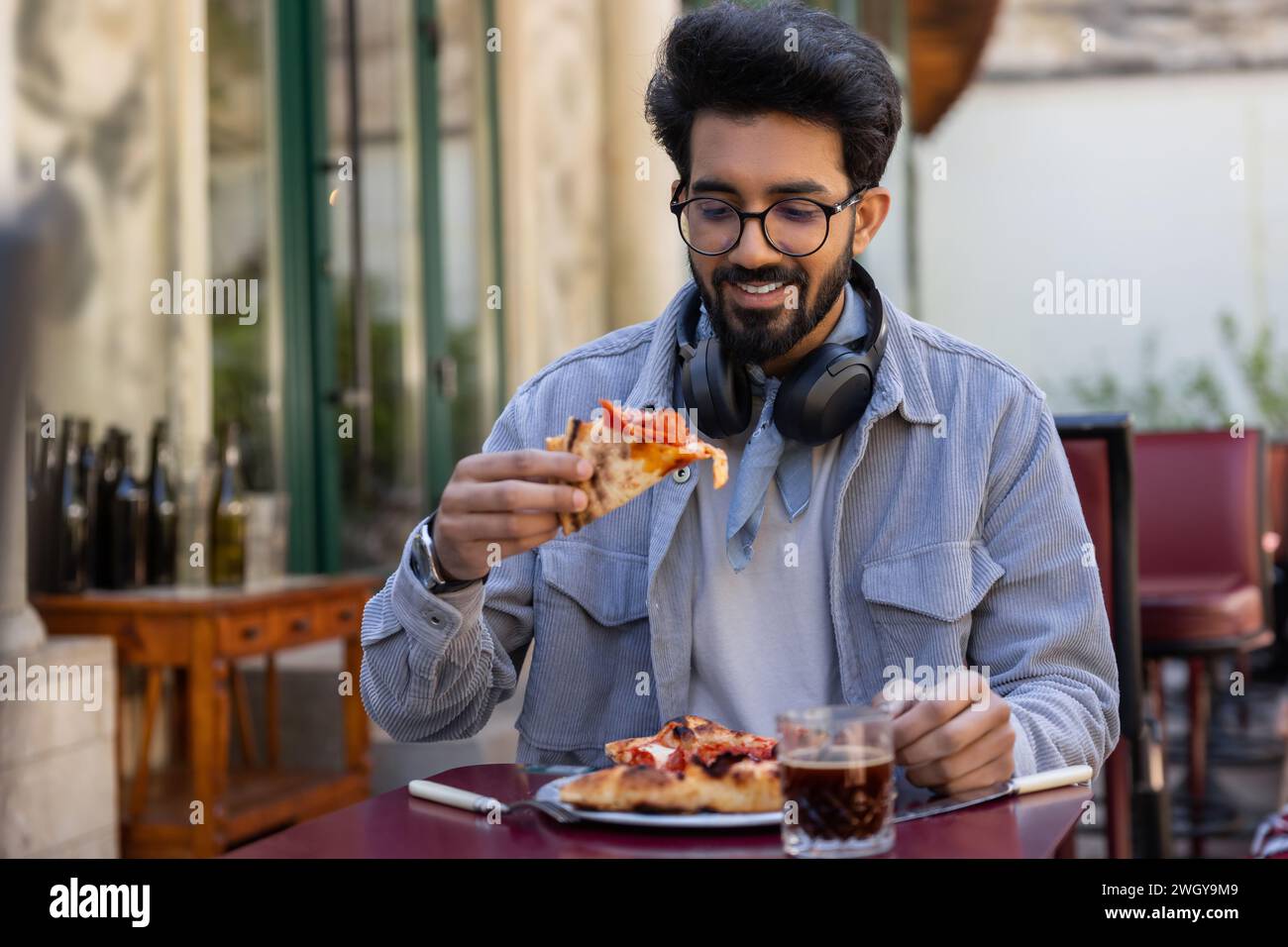 Young hindu man eating pizza in pizzeria Stock Photo - Alamy
