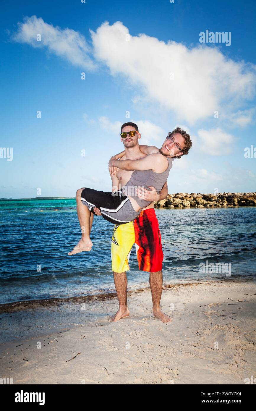Two young men having fun on the beach, Bahamas Stock Photo - Alamy