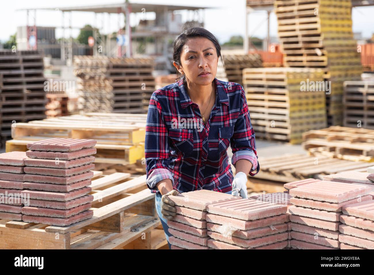 Latin american female stacking tiles on pallet Stock Photo - Alamy