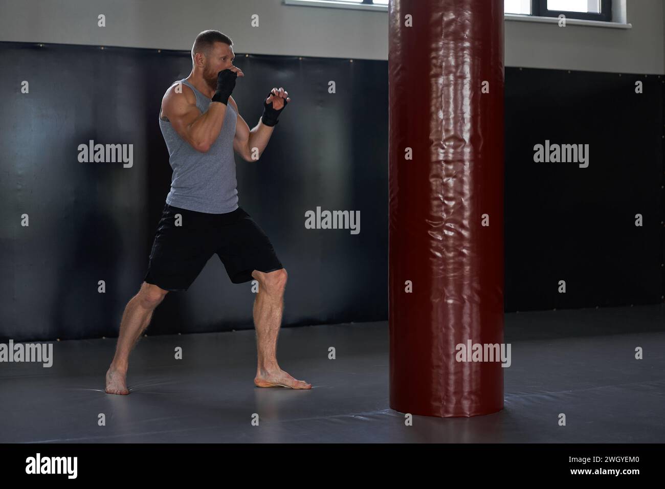 Full body of determined male athlete in sportswear in front of red ...