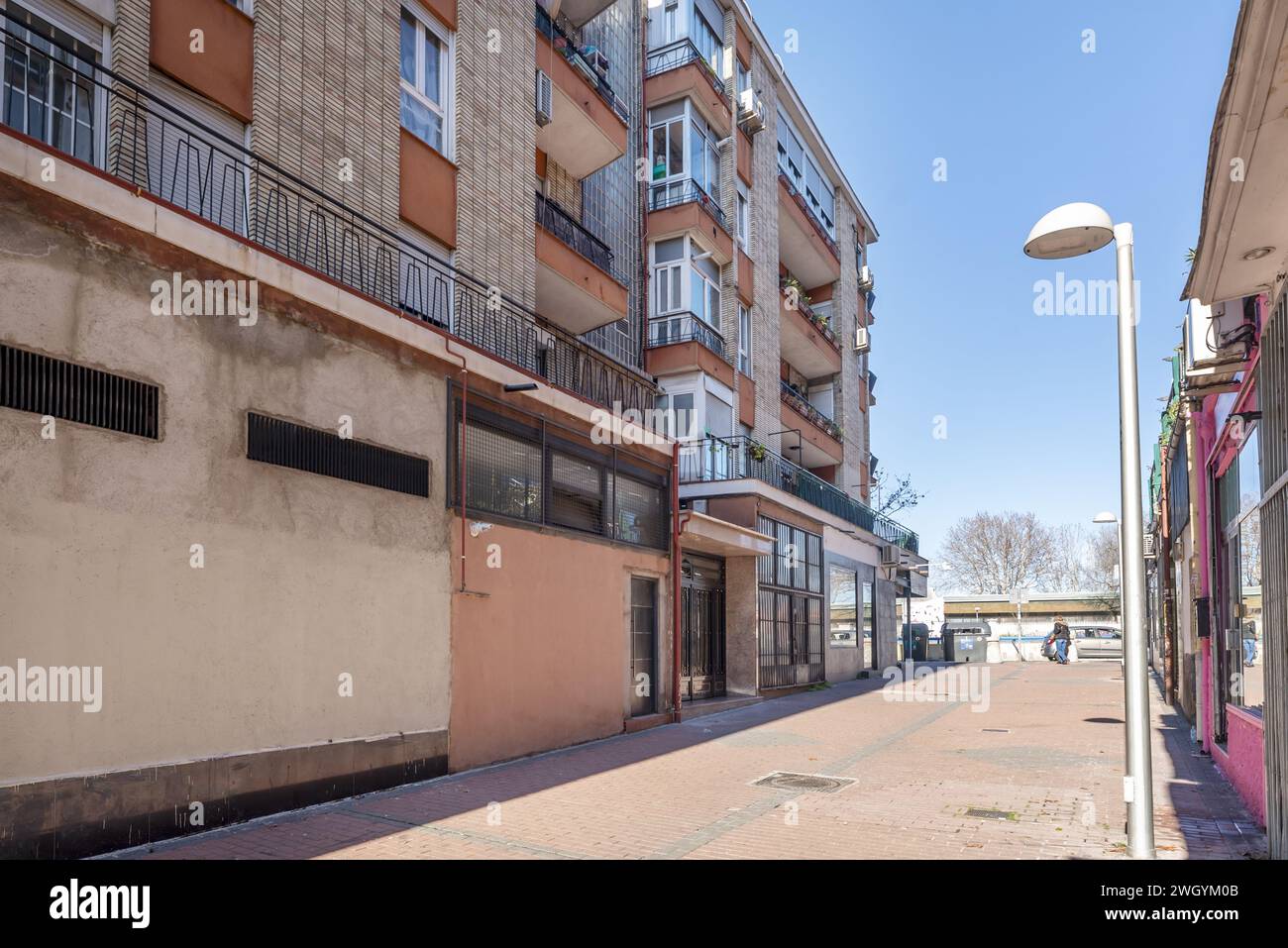 A small pedestrian street lined with residential apartment buildings ...