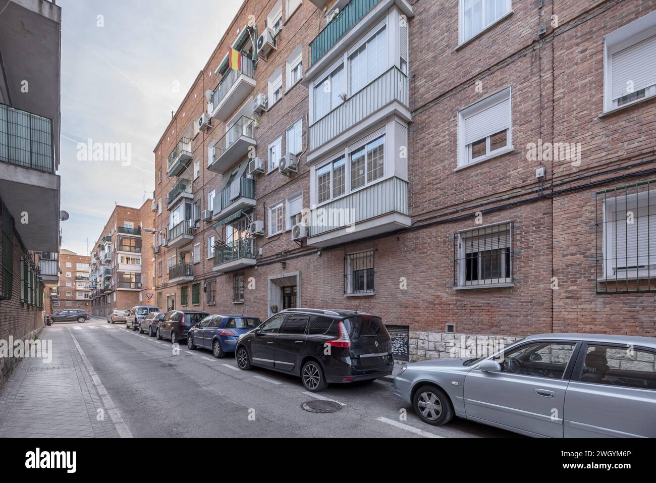 View of a street with many cars parked on one side between parking ...