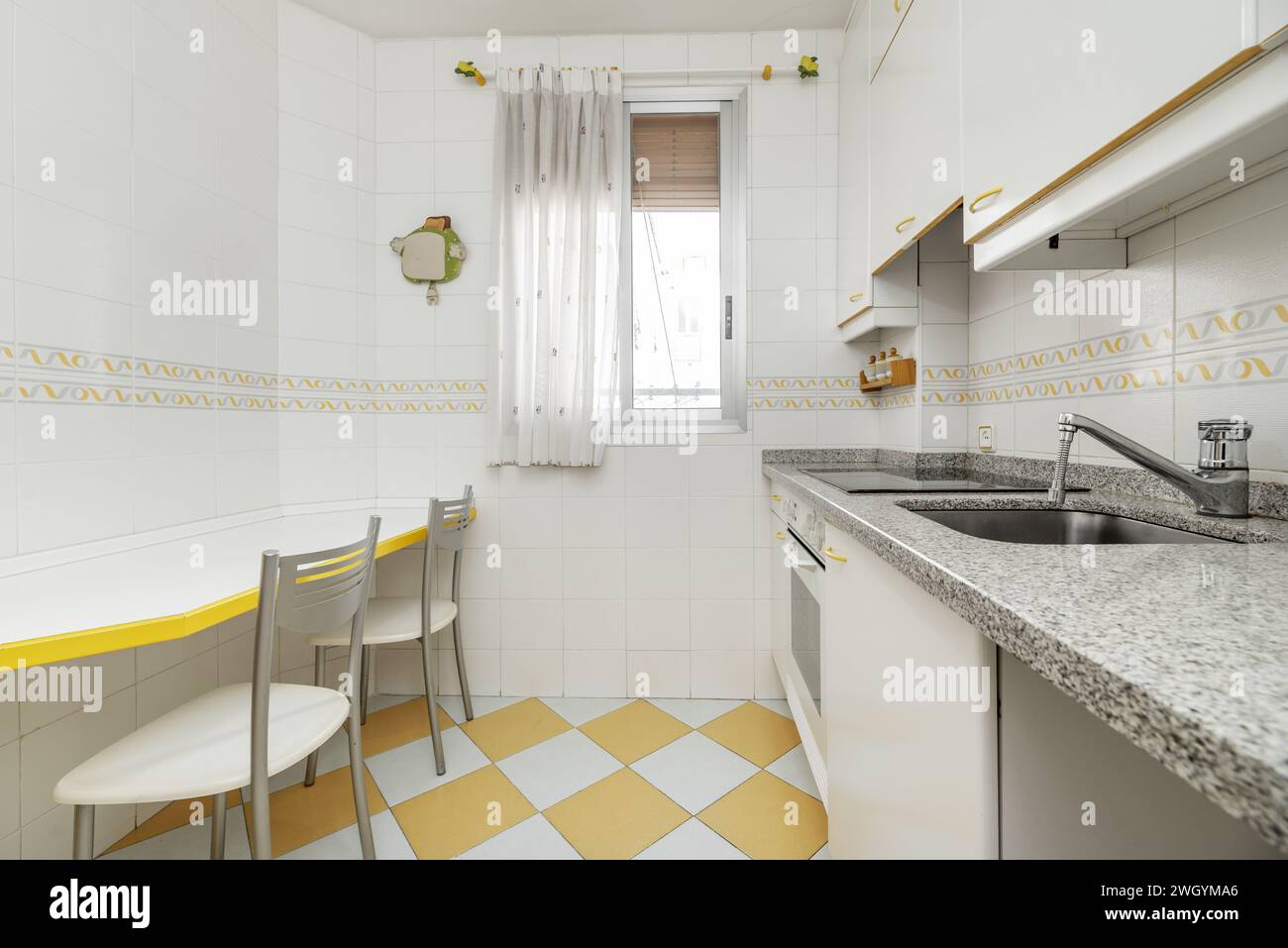 A small white breakfast table with yellow accents, a pair of white ...