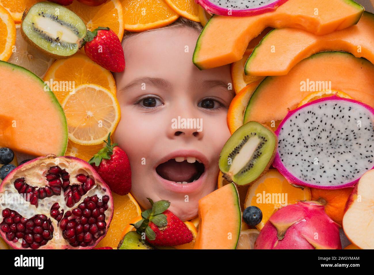 Frutit and child face close up. Top view of excited child face with mix ...