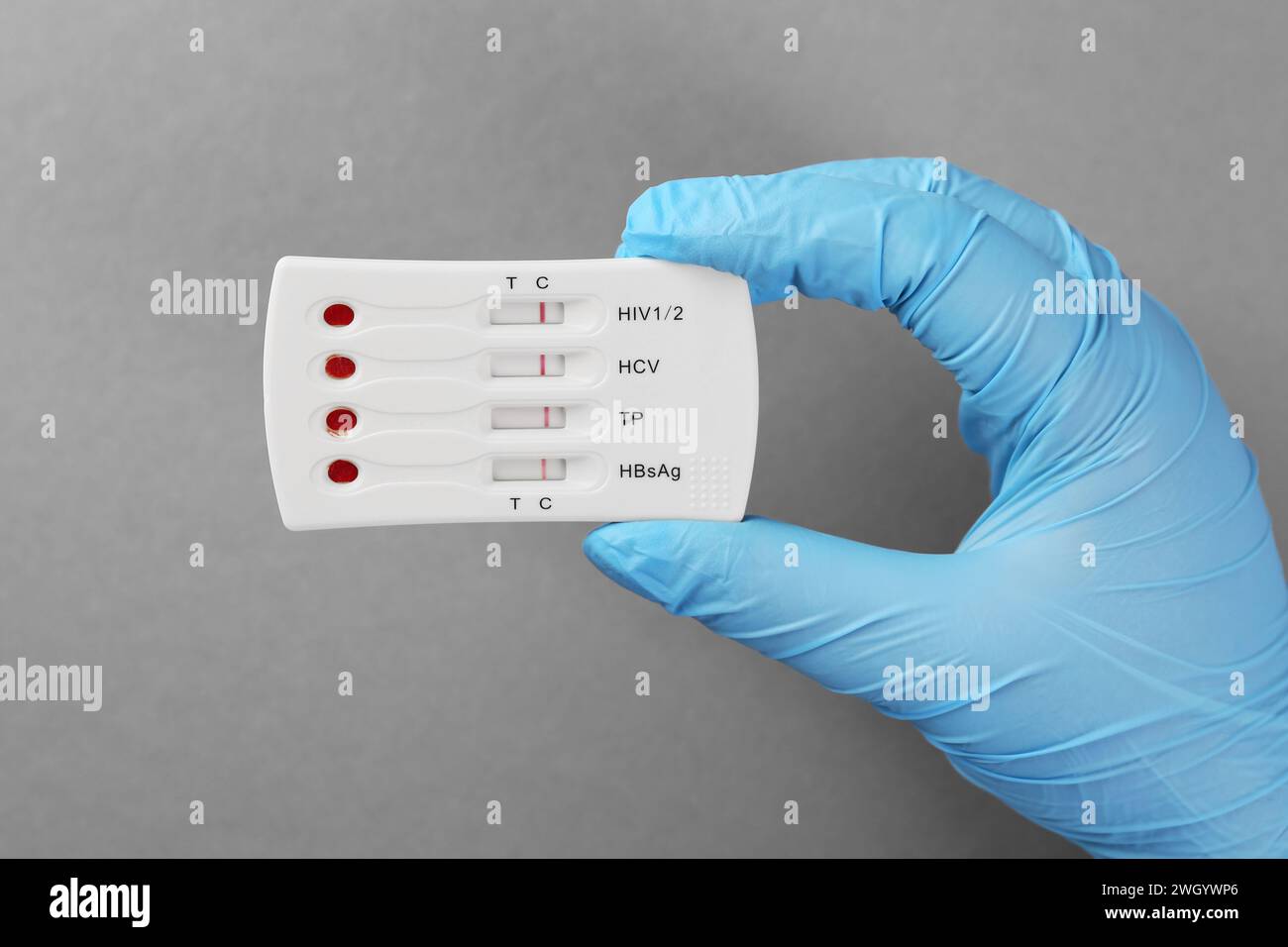 Doctor holding disposable multi-infection express test on light grey ...