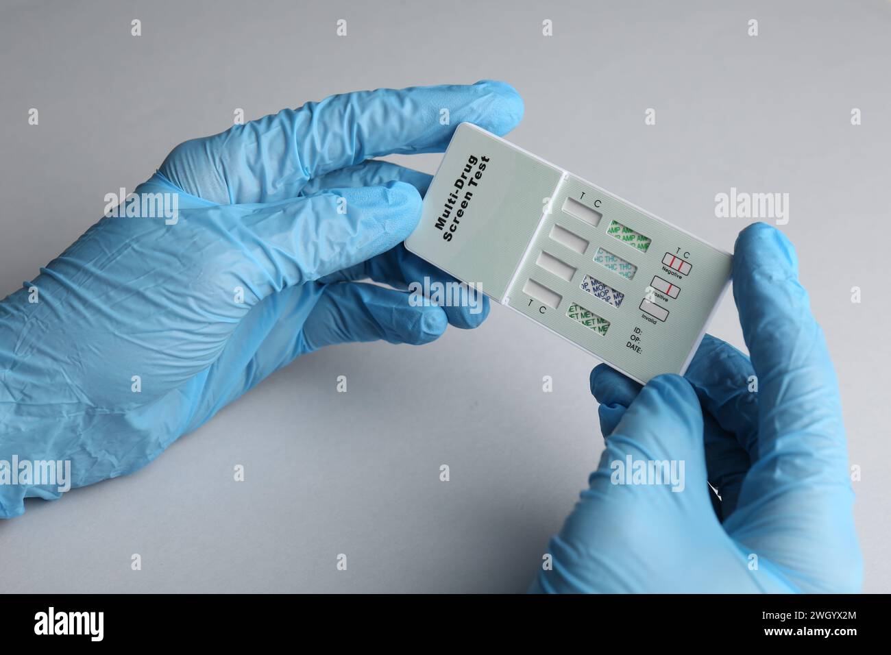 Doctor holding multi-drug screen test on light grey background, closeup ...