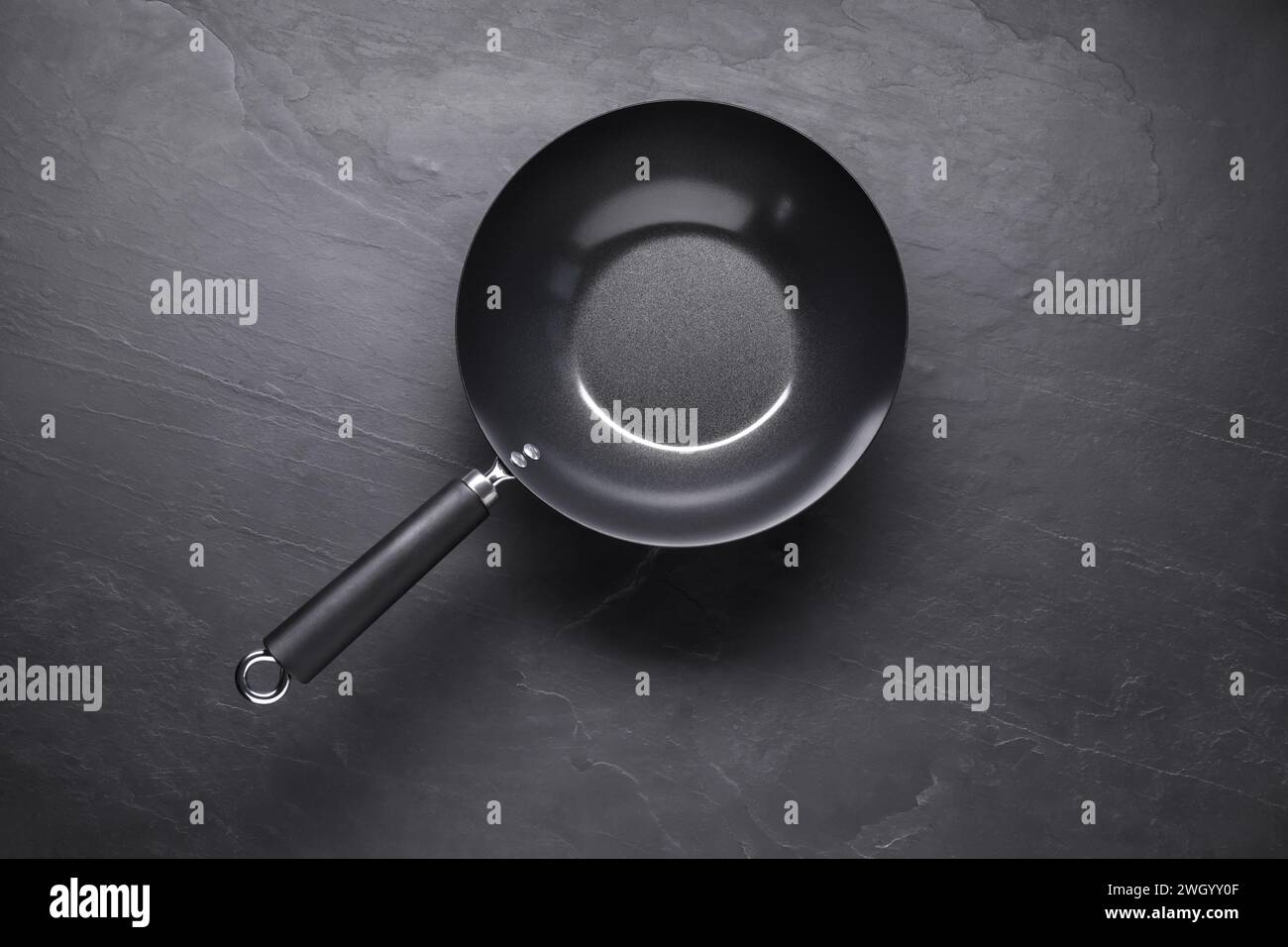 Empty iron wok on black textured table, top view. Chinese cookware ...