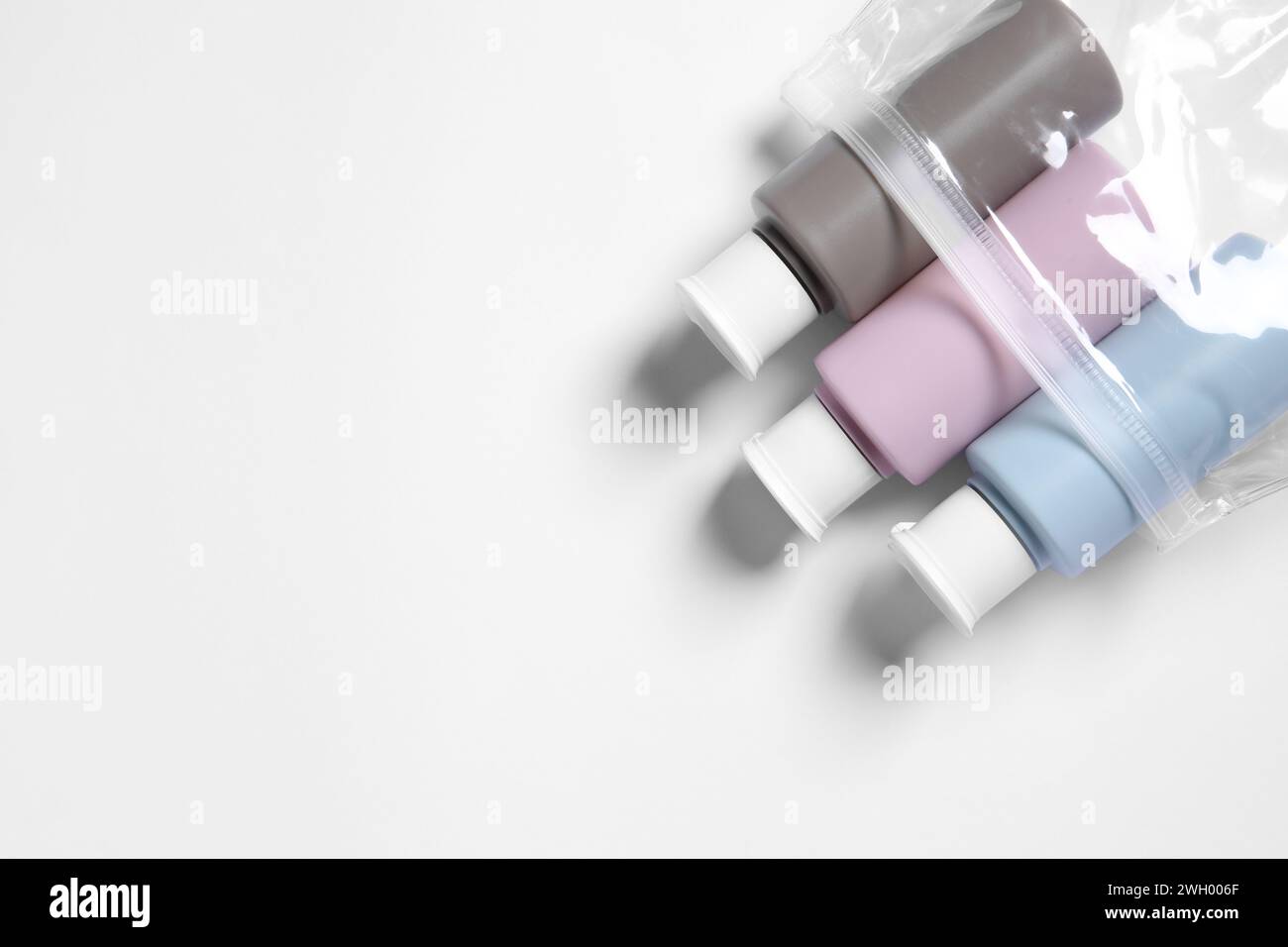 Cosmetic travel kit in plastic bag on white background, top view. Space ...