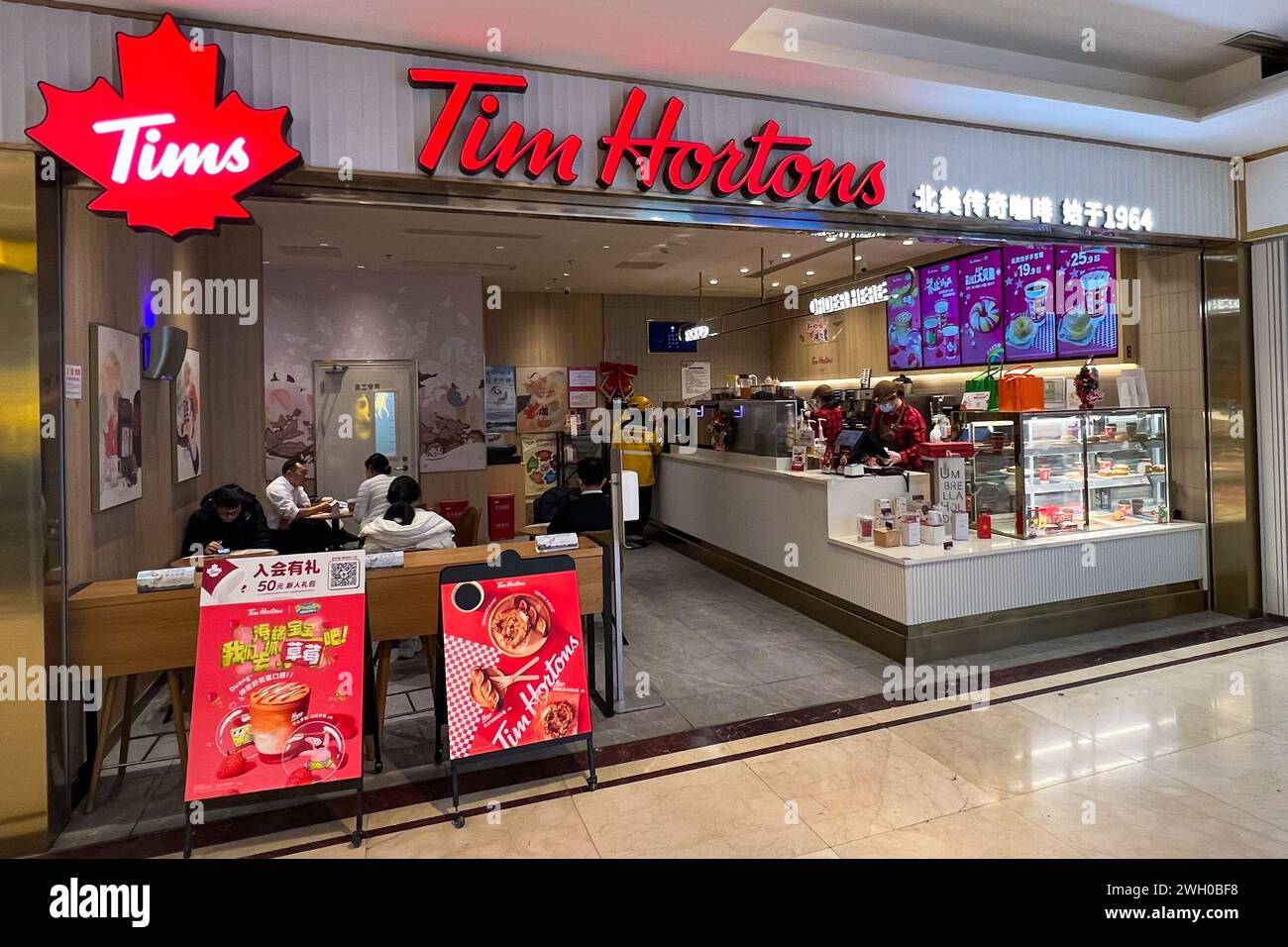 Beijing, China. 08th Dec, 2023. Customers enter a Tim Hortons store in ...