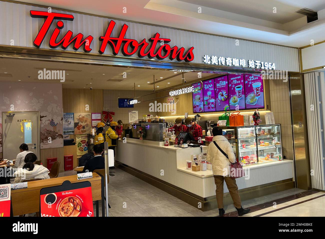 Beijing, China. 08th Dec, 2023. Customers enter a Tim Hortons store in ...