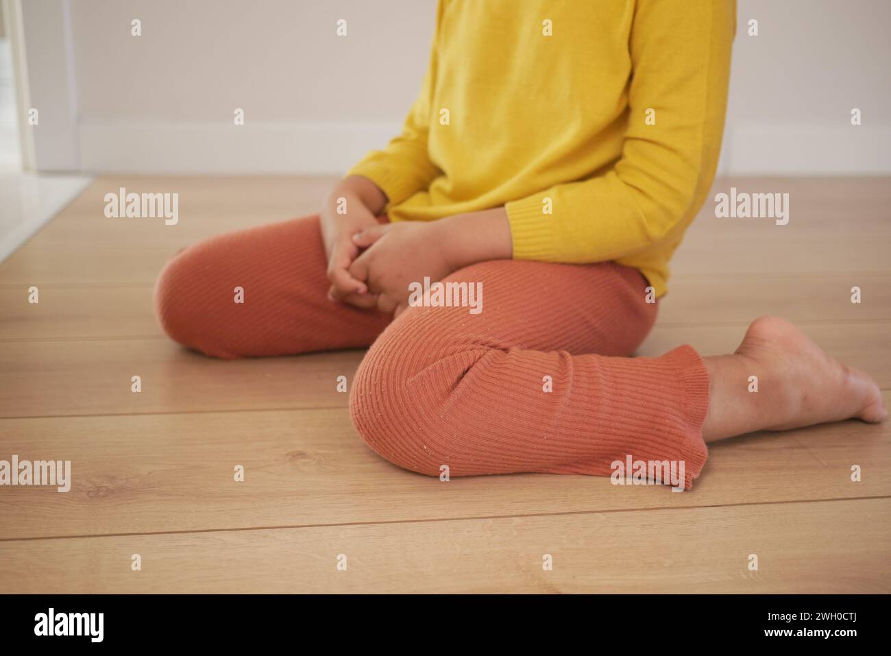 child sitting W posture on the floor Stock Photo - Alamy