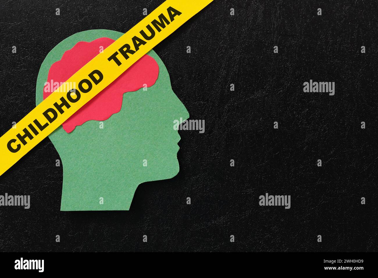 Human head profile with word childhood trauma in dark black background ...