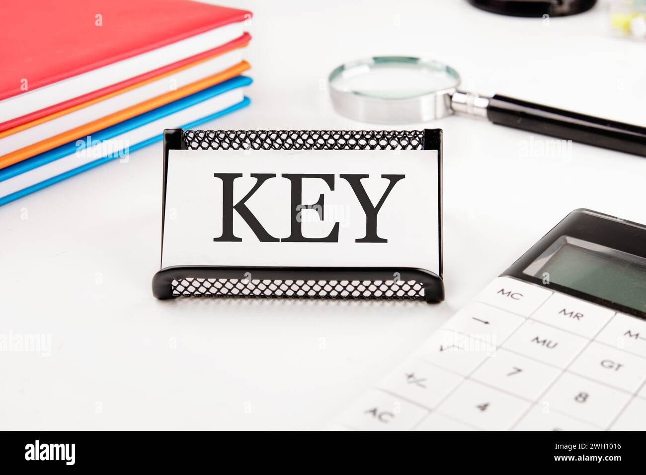 KEY text on a business card next to office supplies on a white ...