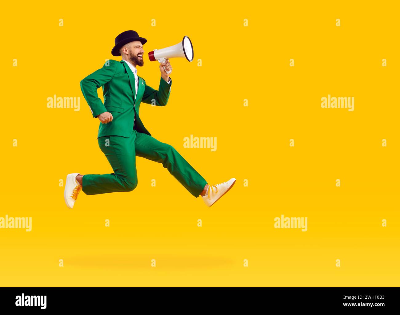 Man with megaphone jumps on copy space background and makes ...
