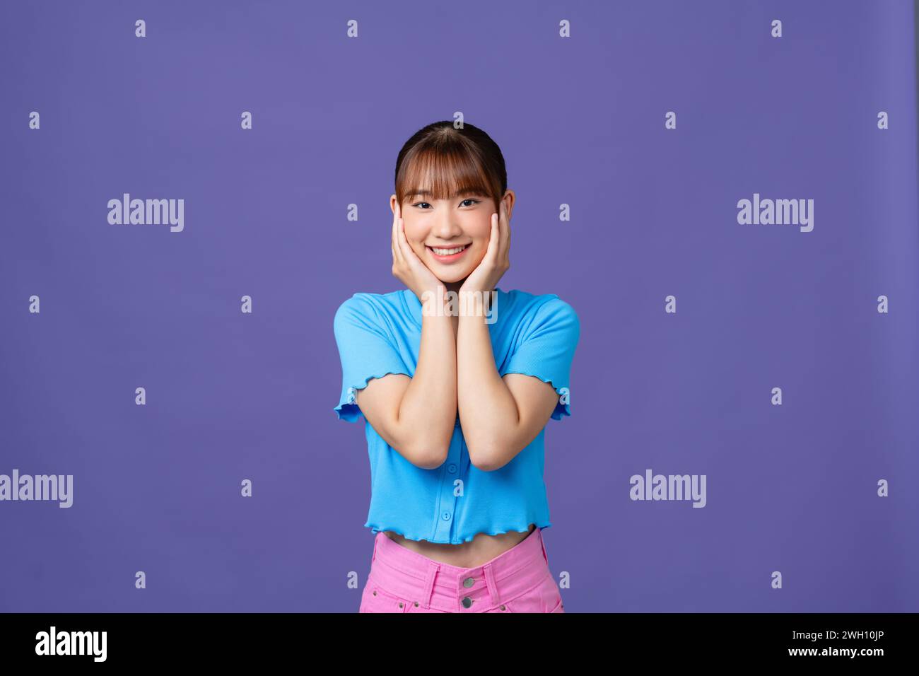 cute amazed girl holding head with two hands isolated on purple ...