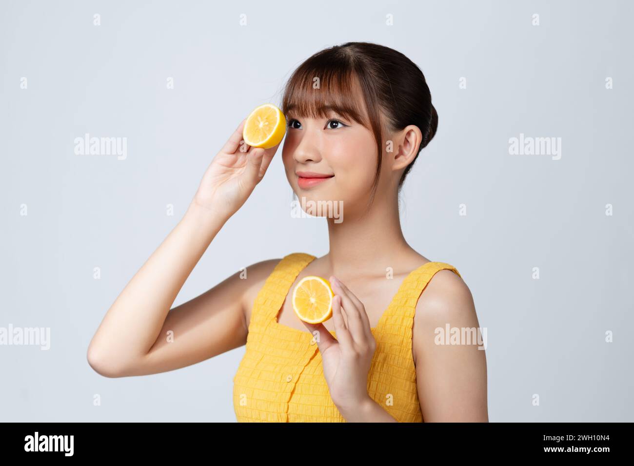 Young beautiful girl with clean healthy skin looking at camera hiding ...