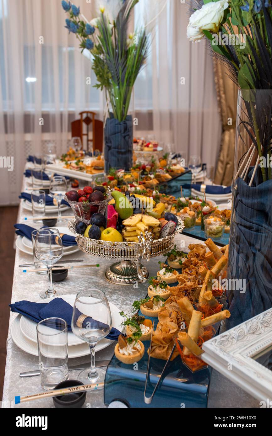 An elegant spread of delectable treats and floral arrangements on a beautifully set dining table ...