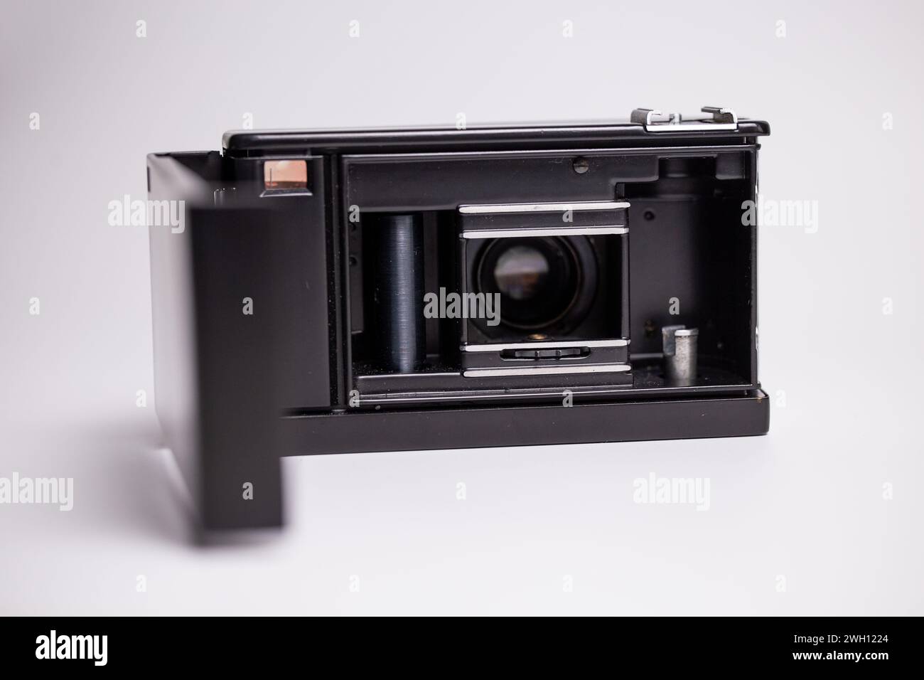 A vintage black and silver retro camera with an open back, revealing a ...