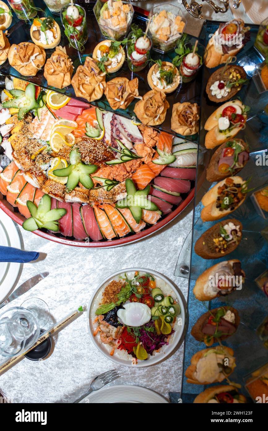 A stunning display of sumptuous sushi and canapes on a glass table ...