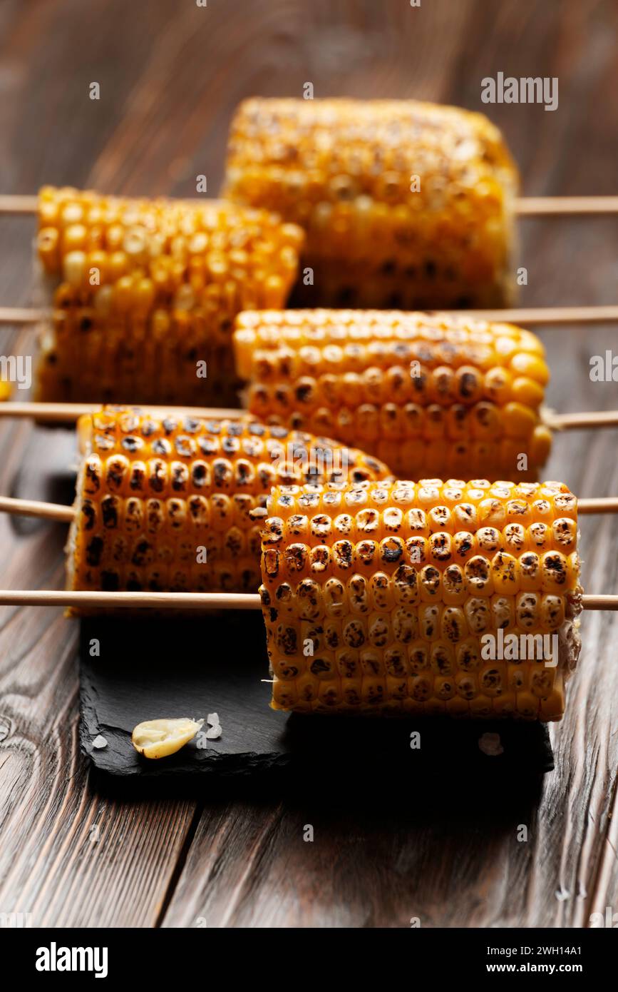 Slate tray with Pieces of Grilled corn on the cob on kitchen table ...
