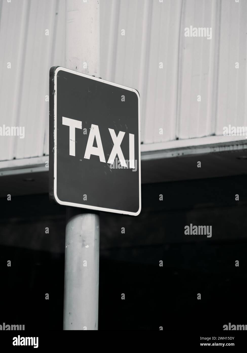 Monochrome Image of a Taxi Sign Against Industrial Background Stock ...